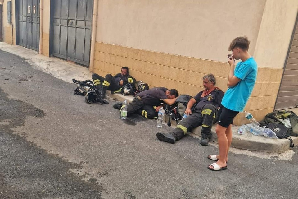 La foto simbolo degli incendi nel Sud Italia: vigili del fuoco stremati